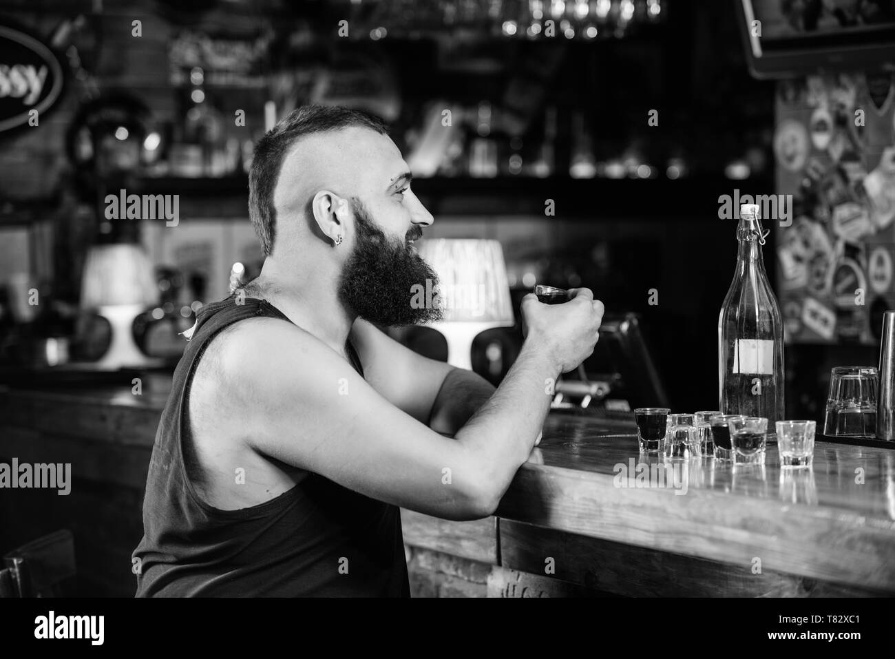 Hipster brutal man drinking alcohol ordering more drinks at bar counter ...