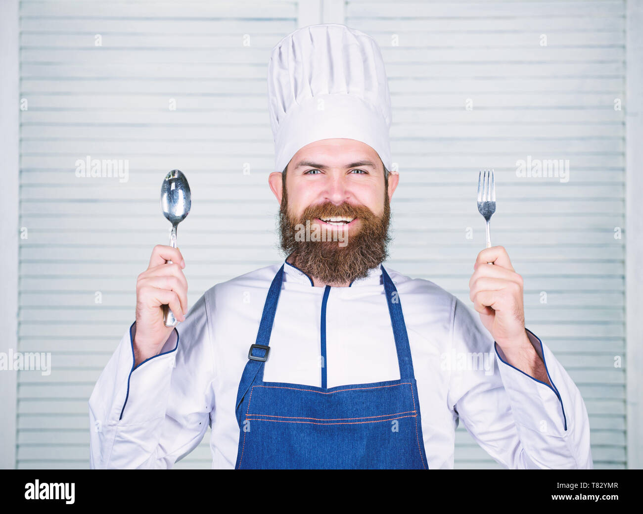 Chef happy smiling face hold spoon and fork. Man handsome with beard ...
