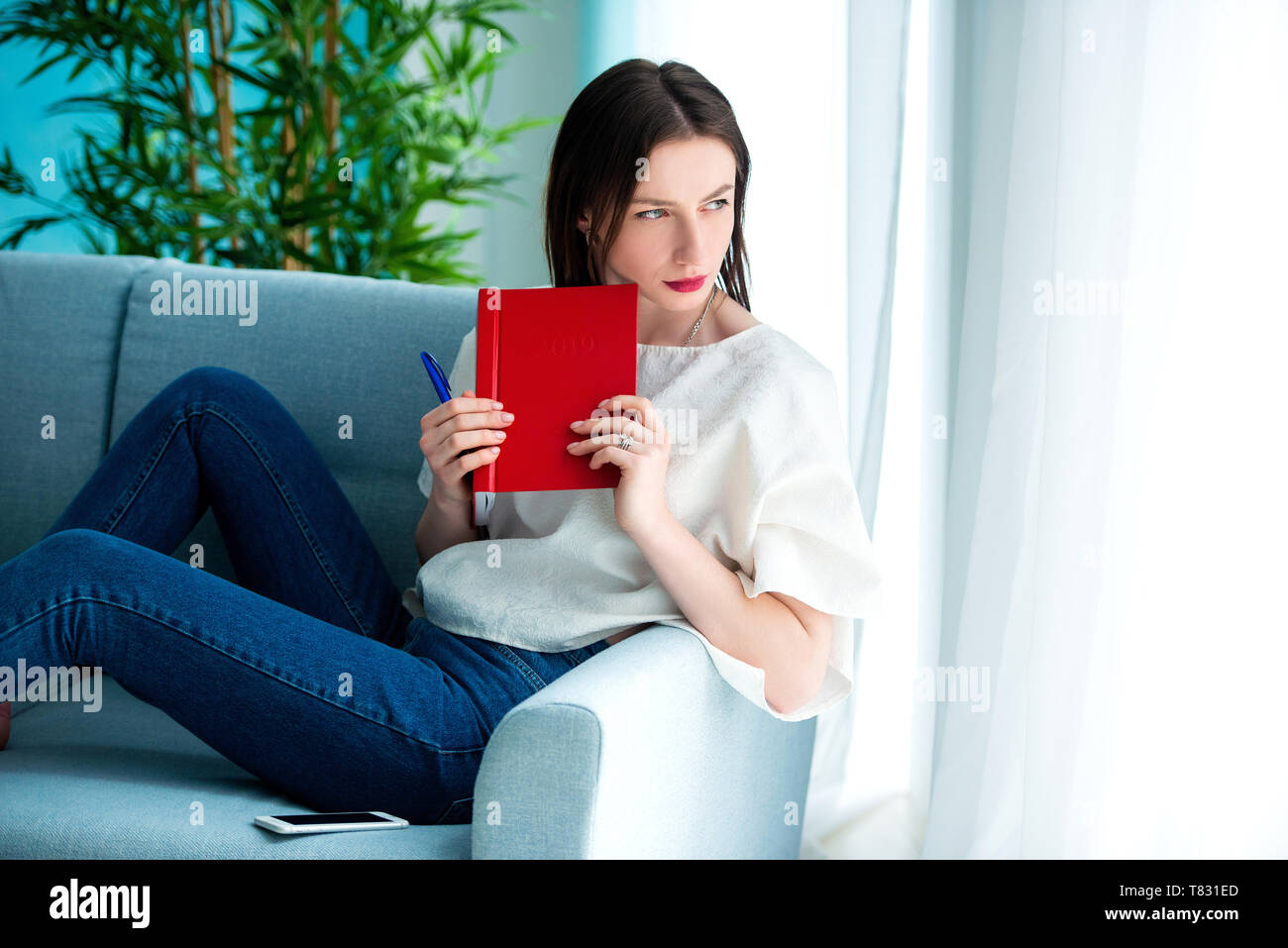 girl with a red note book at home Stock Photo - Alamy