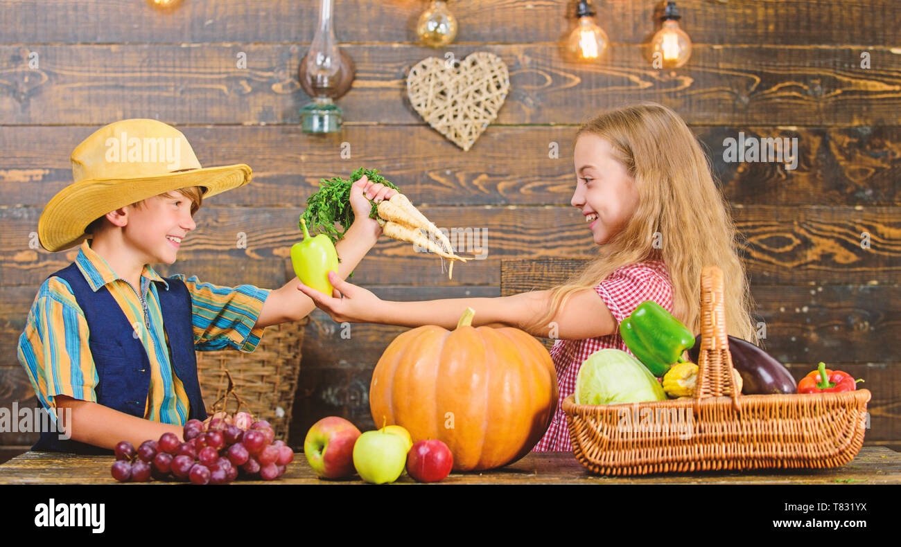 Children presenting farm harvest wooden background. Kids farmers girl ...