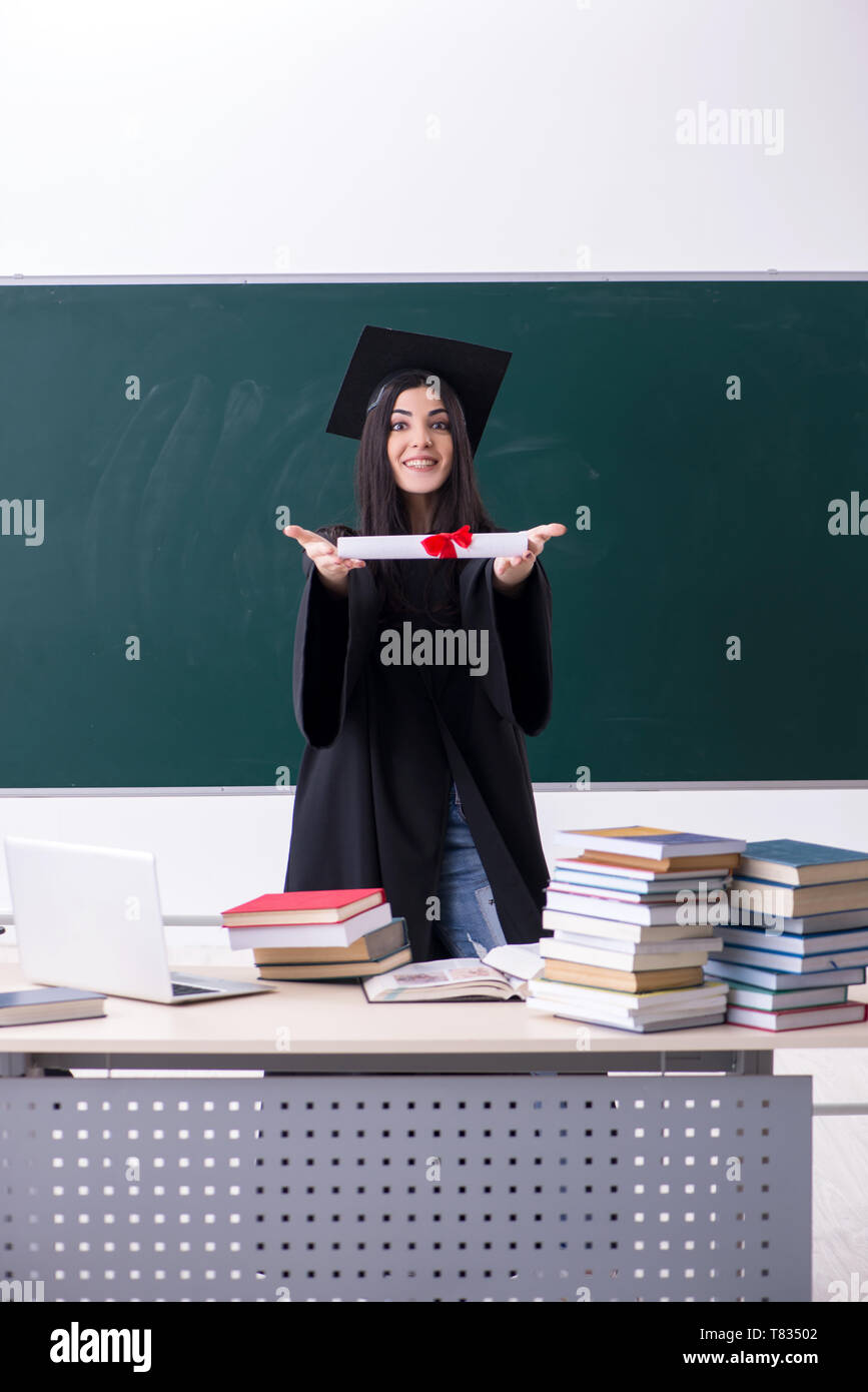 Female graduate student in front of green board Stock Photo - Alamy