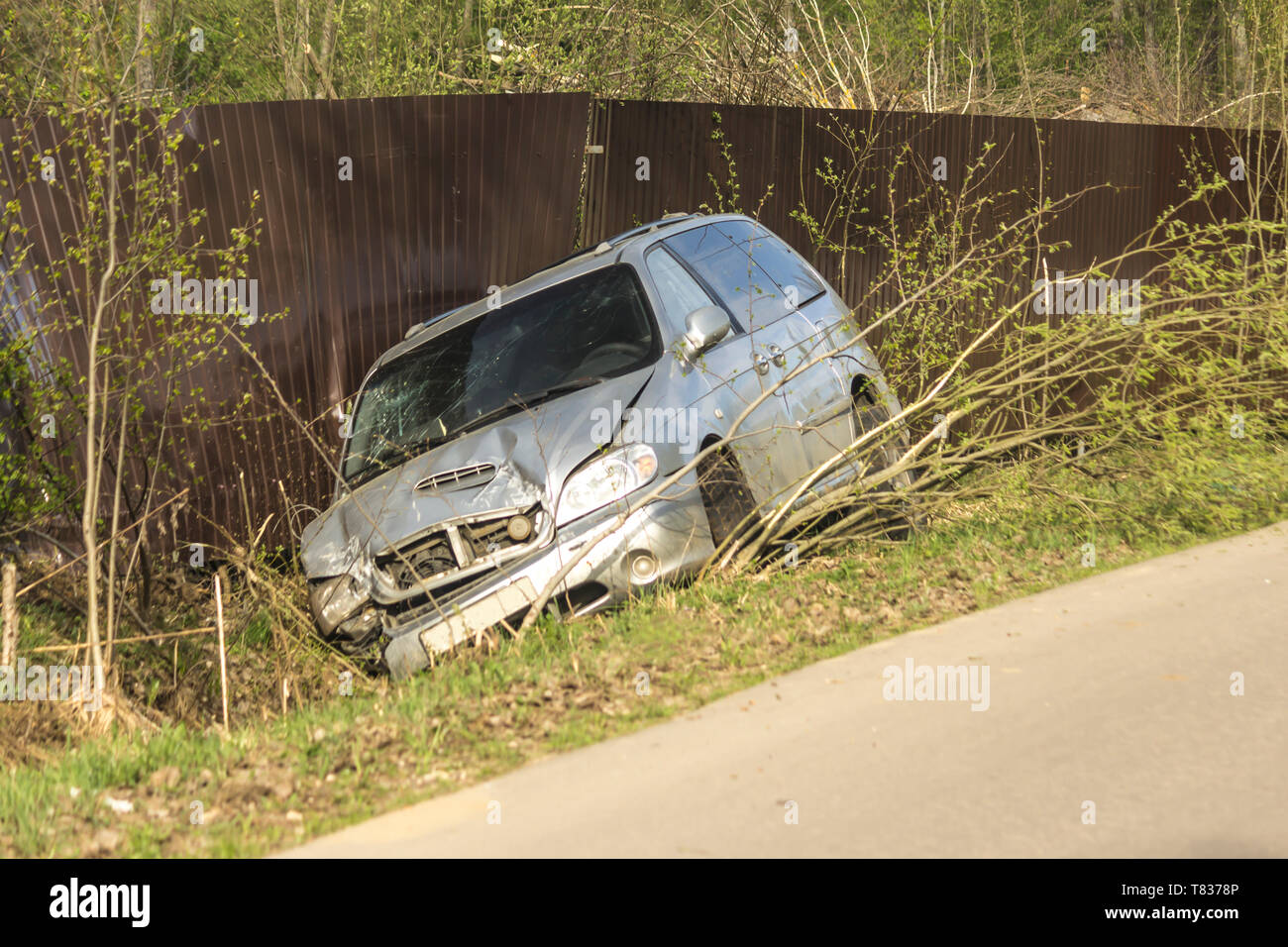 Car accident on a country road. The car is broken in front, slid into a ...