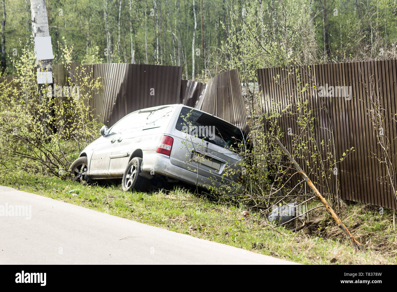 Car accident on a country road. The car is broken in front, slid into a ...