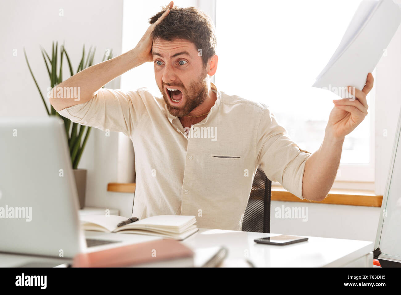 Image of shocked office worker 30s wearing white shirt using laptop and ...