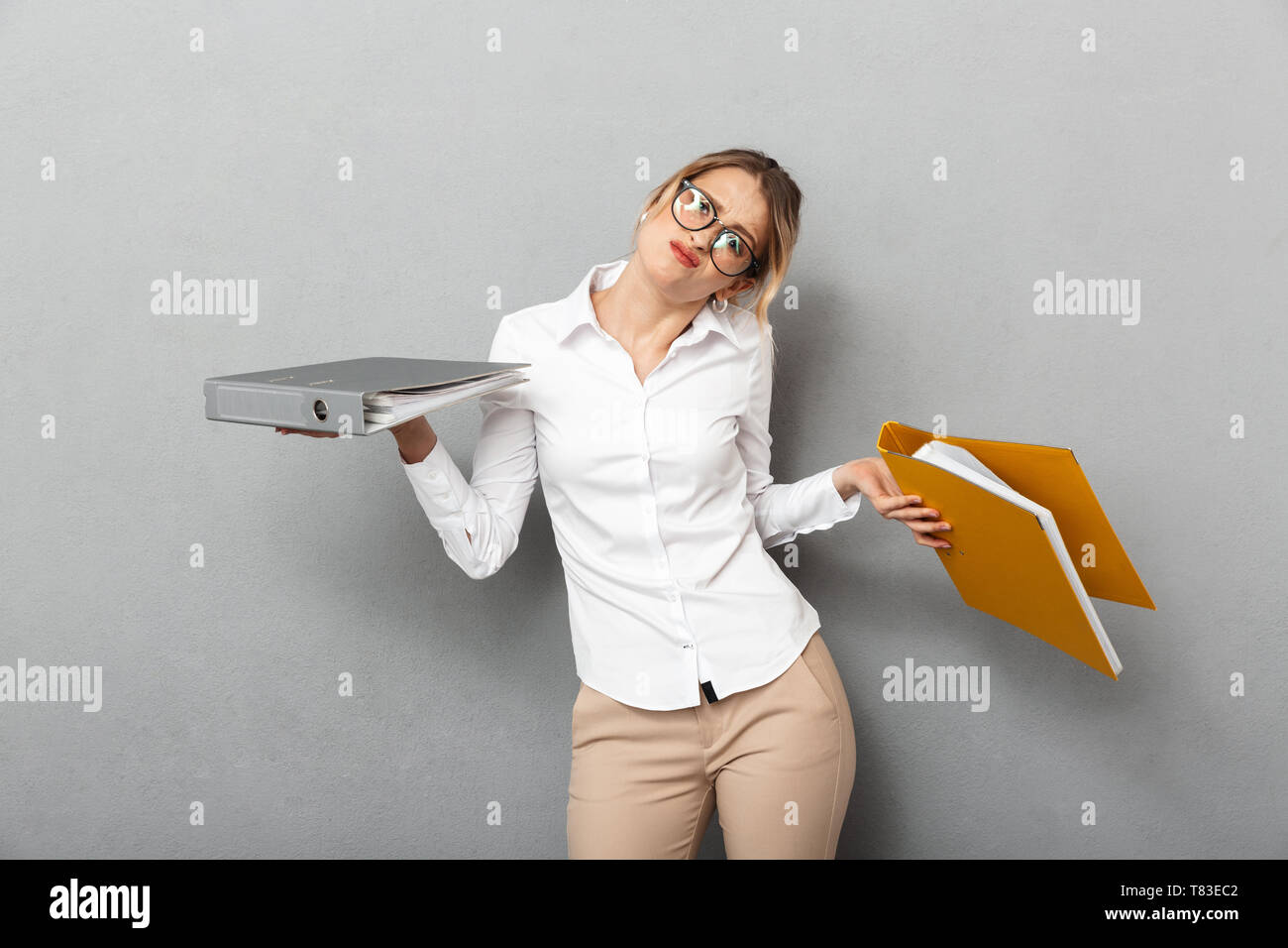 Image of a young confused business woman isolated over grey wall ...