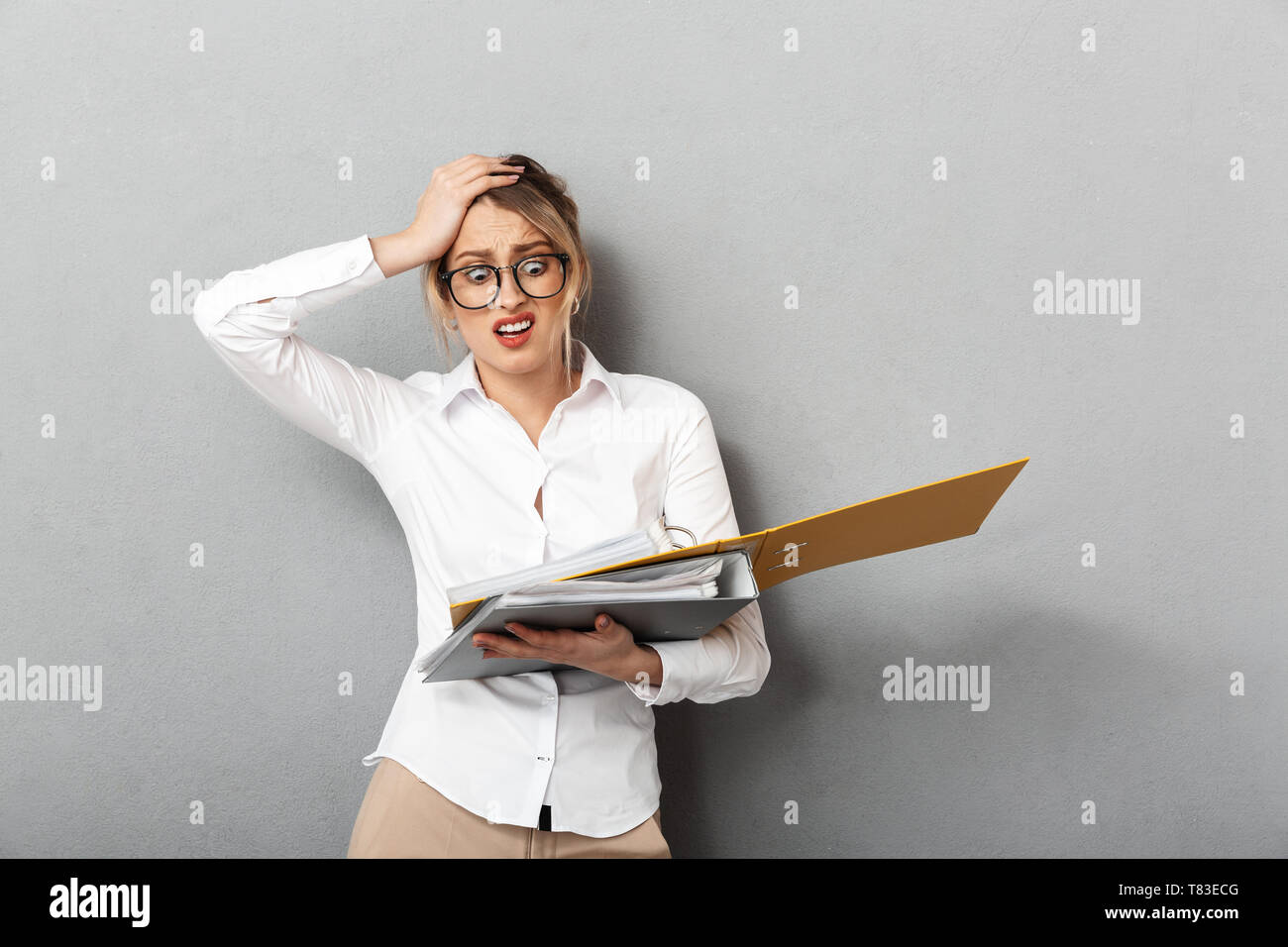 Image of a young confused business woman isolated over grey wall ...
