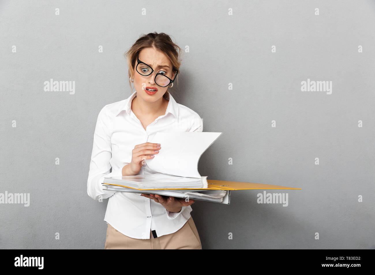 Image of a young confused business woman isolated over grey wall ...