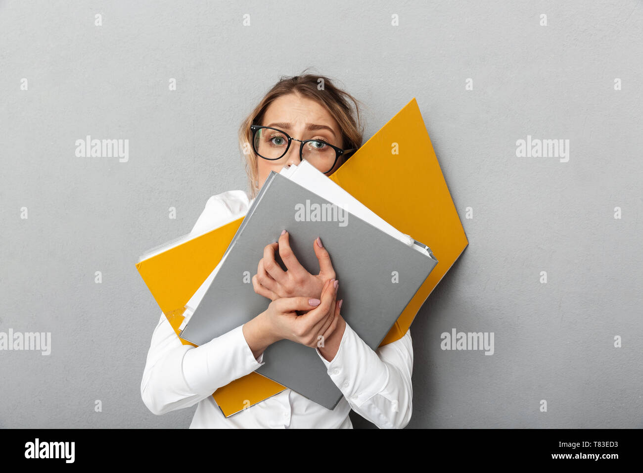Image of a young confused business woman isolated over grey wall ...