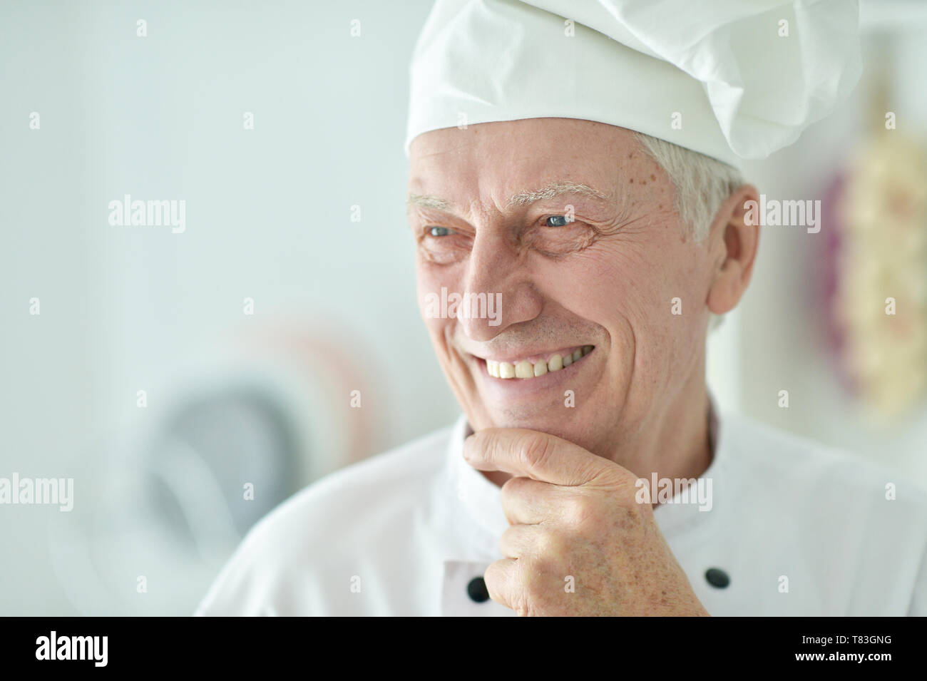 Close-up portrait of happy elderly male chef posing at home Stock Photo ...
