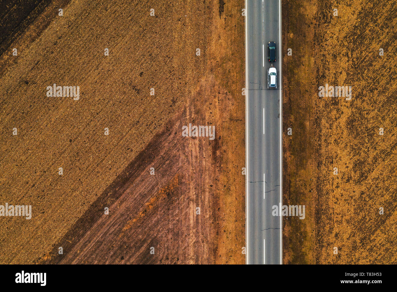 Aerial view of towing car on straight road through countryside from ...