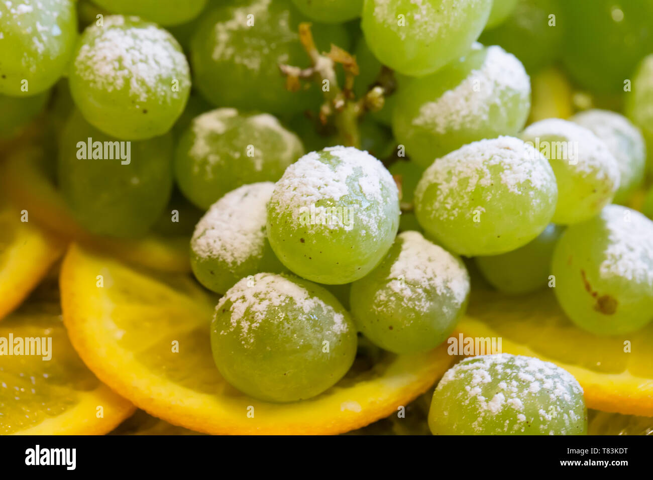Green grapes with powdered sugar. Fruit dessert Stock Photo - Alamy