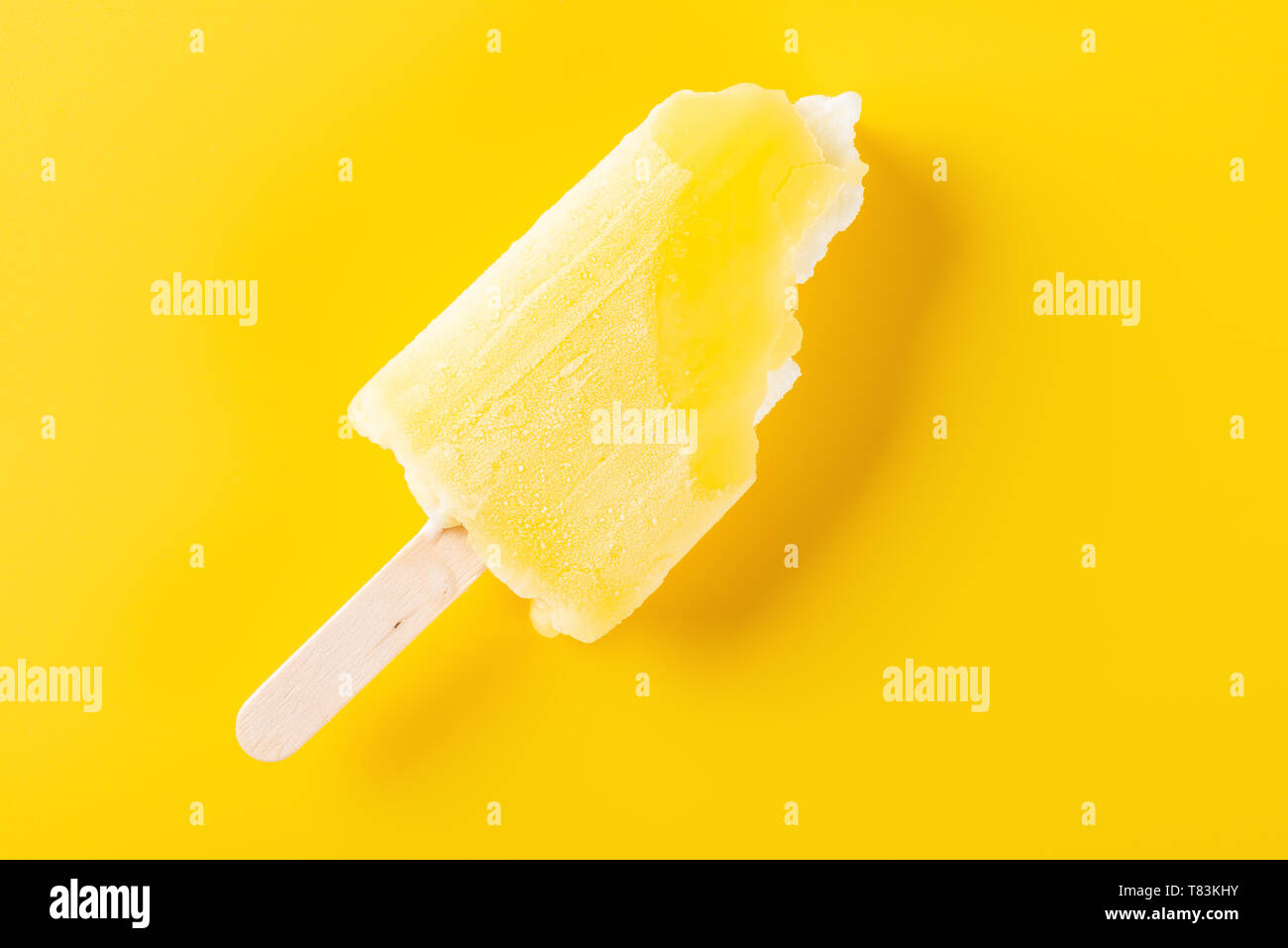 top view yellow popsicle with bites on a yellow background Stock Photo ...