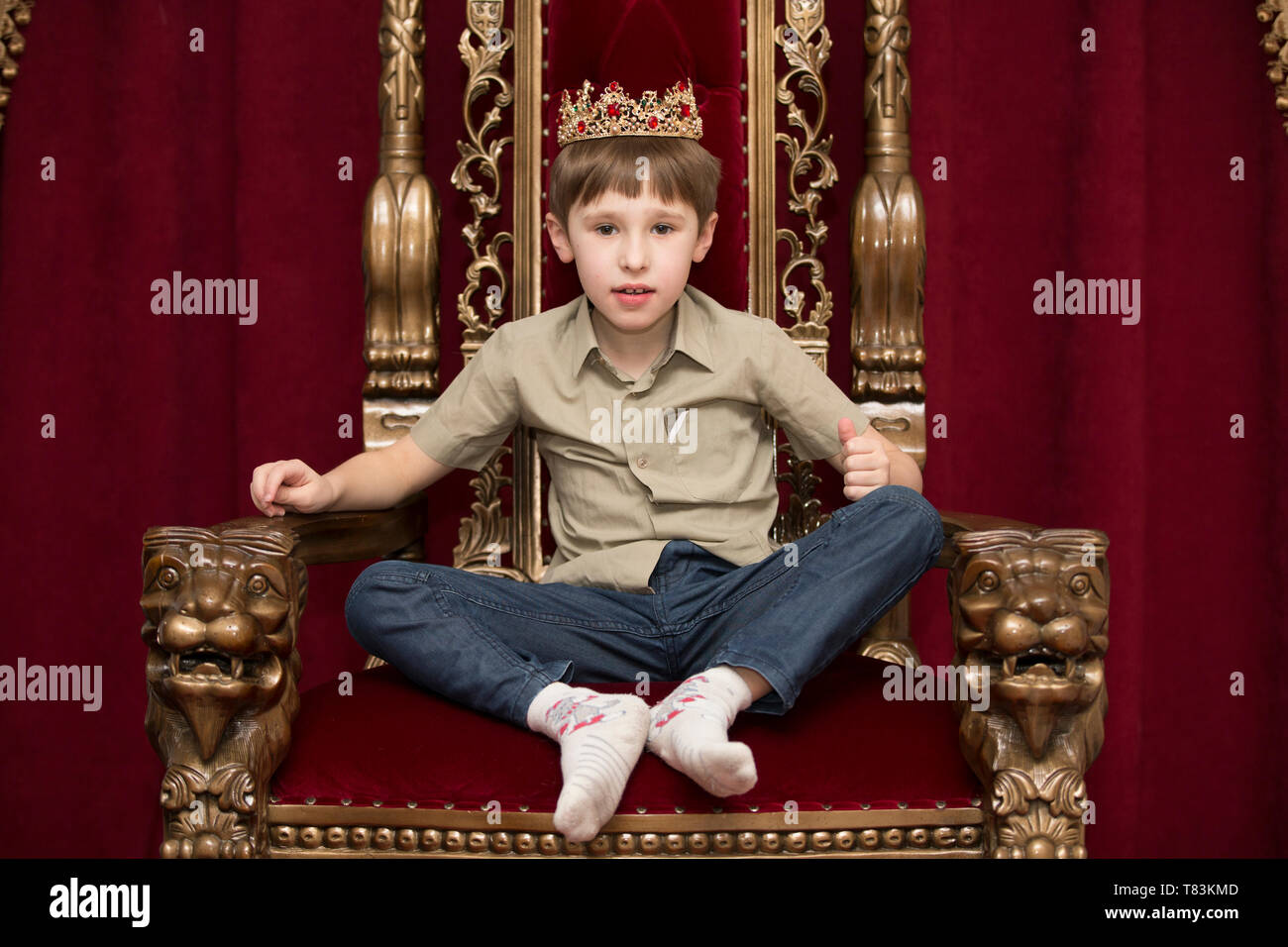 A child with a crown in the royal chair Stock Photo - Alamy