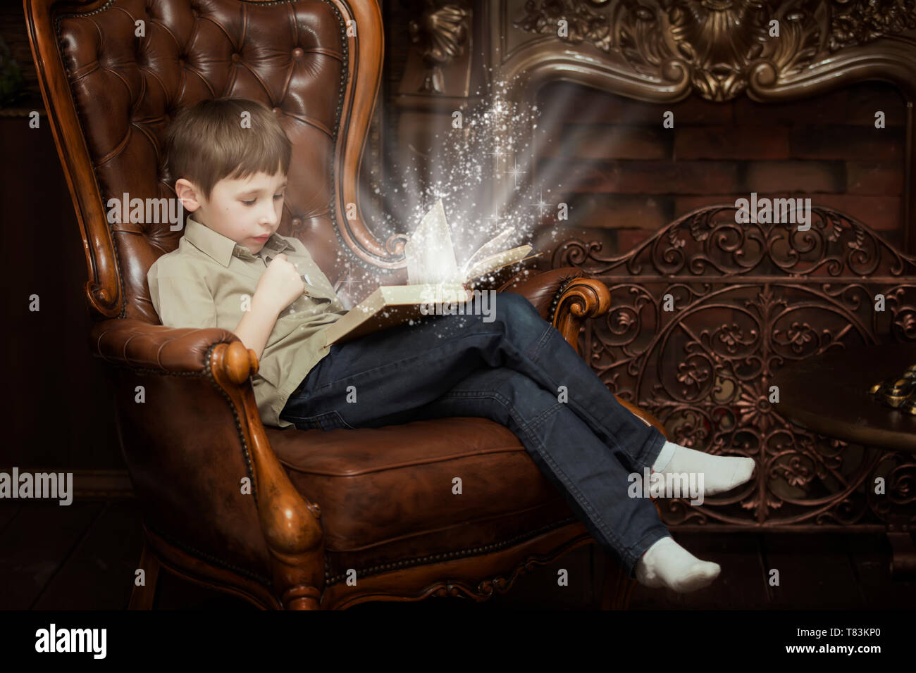 Little boy reading in armchair hi-res stock photography and images - Alamy