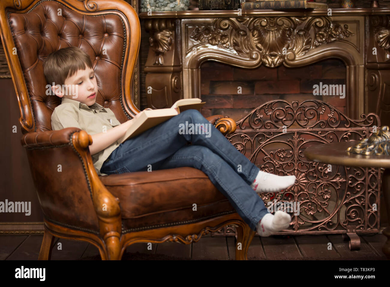 The child in the chair reading a book.Little boy with a book Stock ...