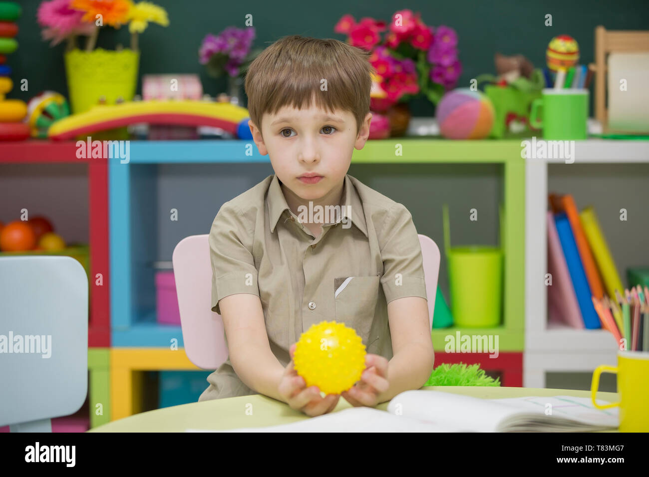 Sad preschooler with a ball in his hands. Junior school student at the ...