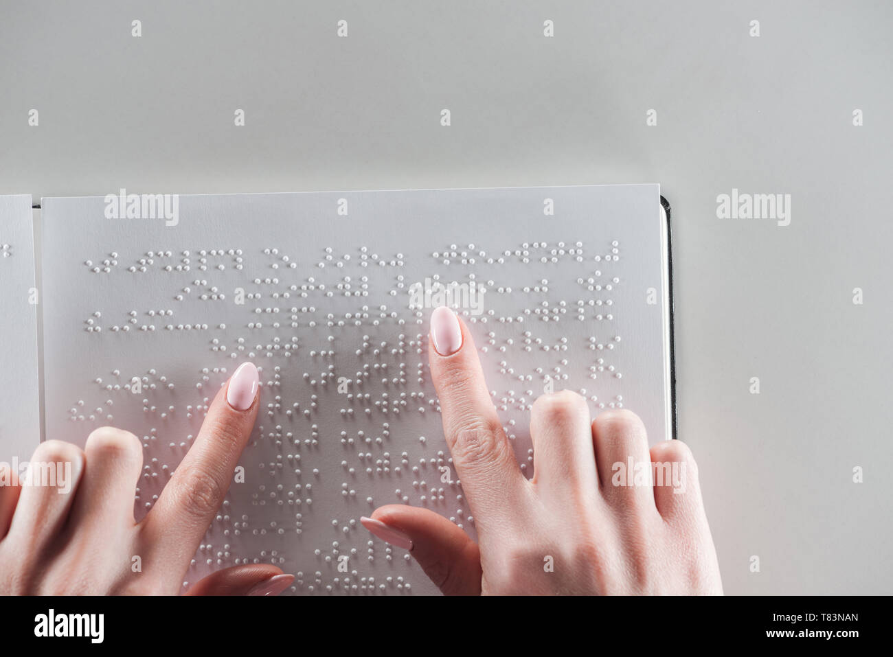 top view of young woman reading braille text on white paper isolated on ...