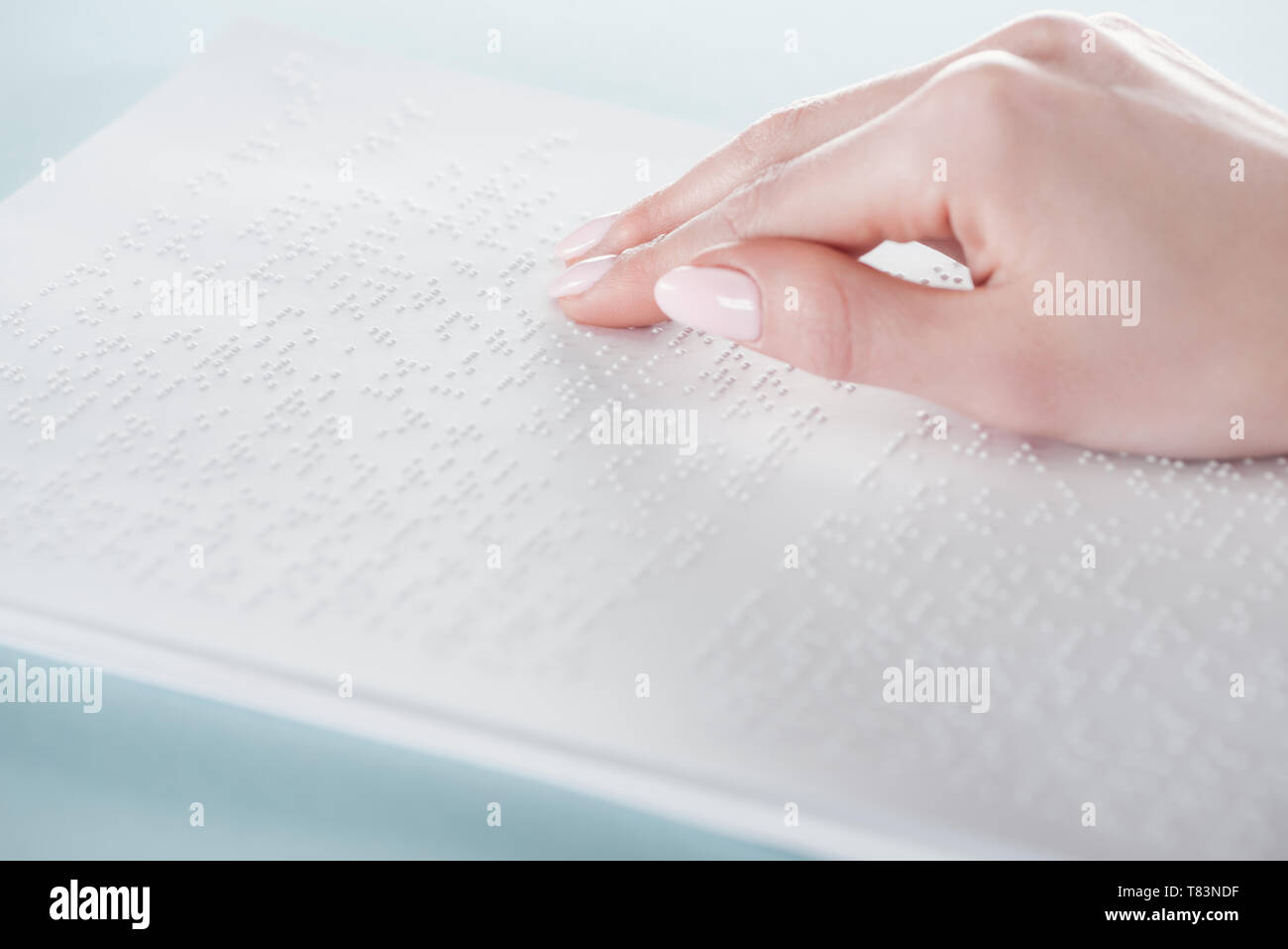 close up view of young woman reading braille text on white paper Stock ...