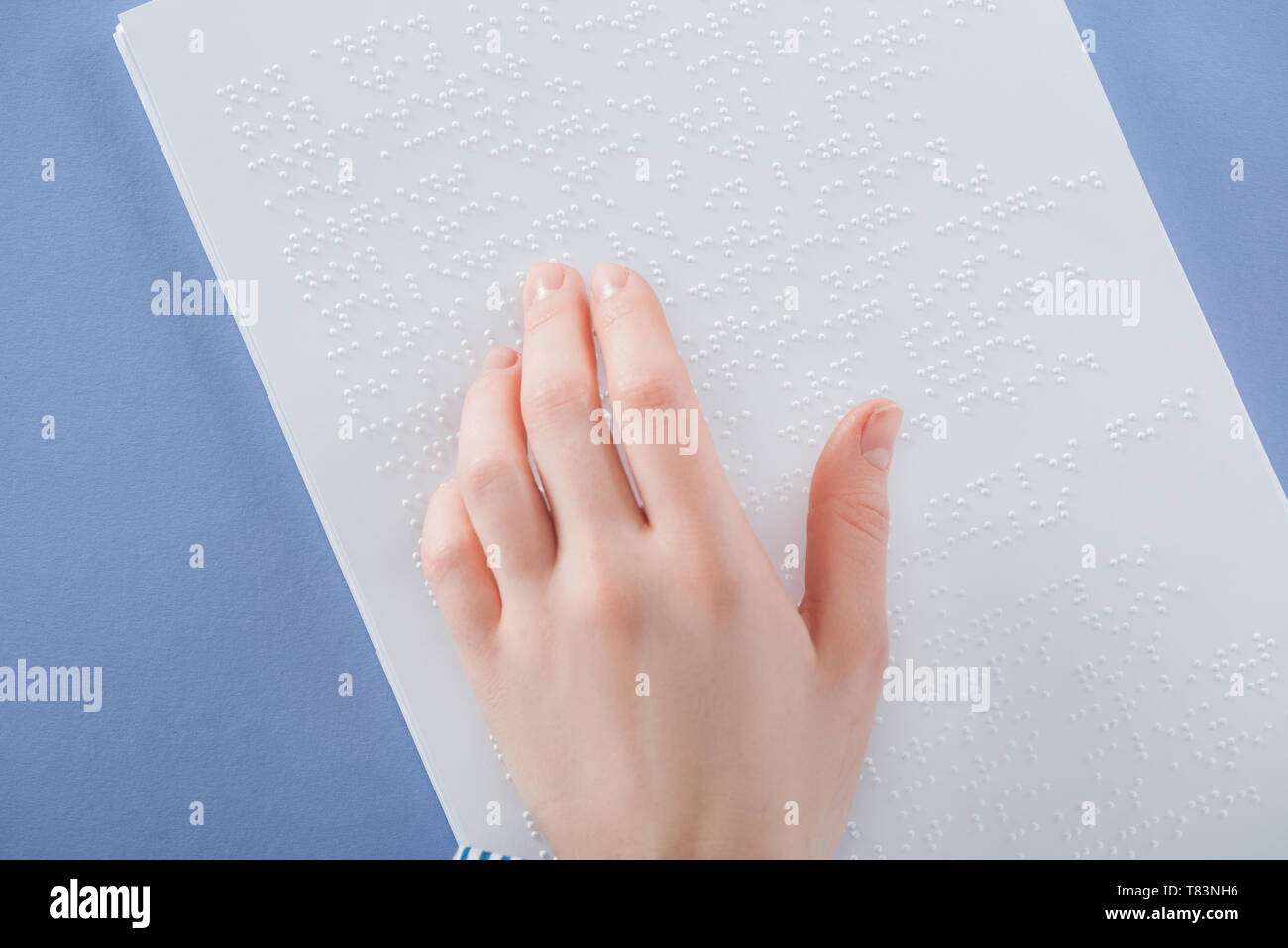 top view of young woman reading braille text with hand isolated on ...