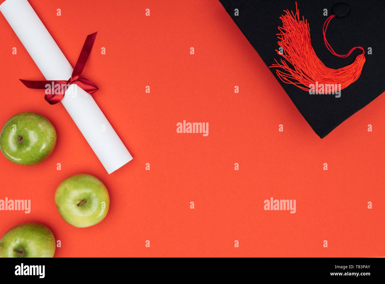 Top view of academic cap, diploma and apples on red surface Stock Photo ...
