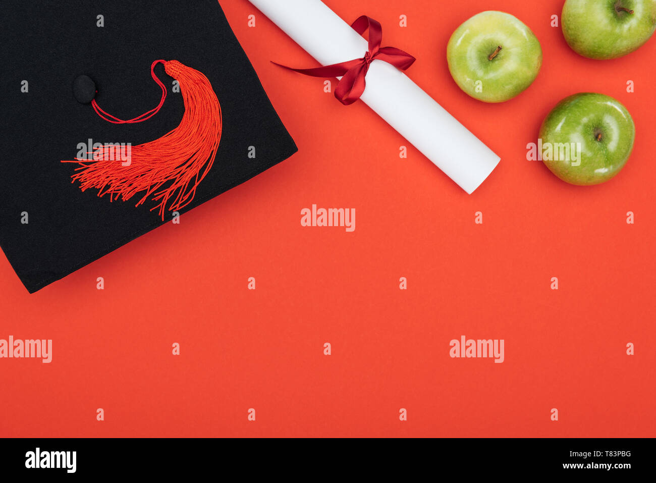 Top view of academic cap, diploma and apples on red surface Stock Photo ...