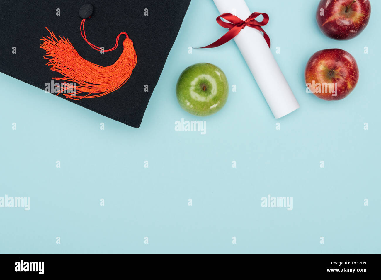 Top view of academic cap, diploma and apples on blue surface Stock ...