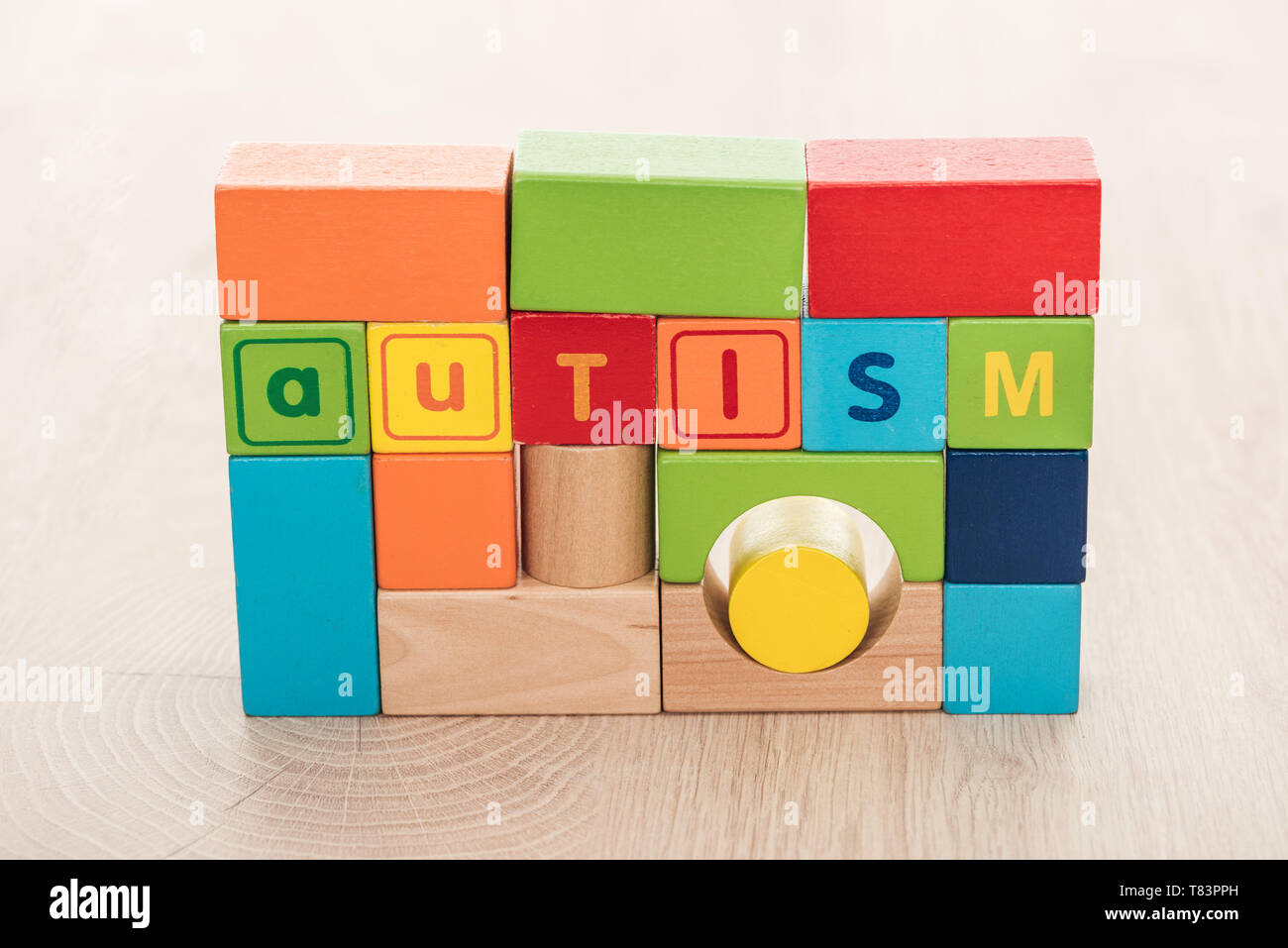 autism lettering made of colorful building blocks on wooden surface ...