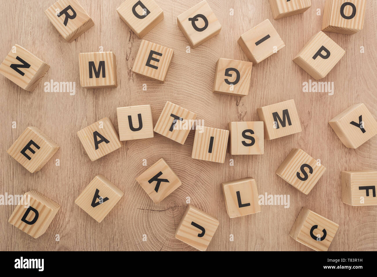 top view of autism lettering made of wooden cubes with different ...
