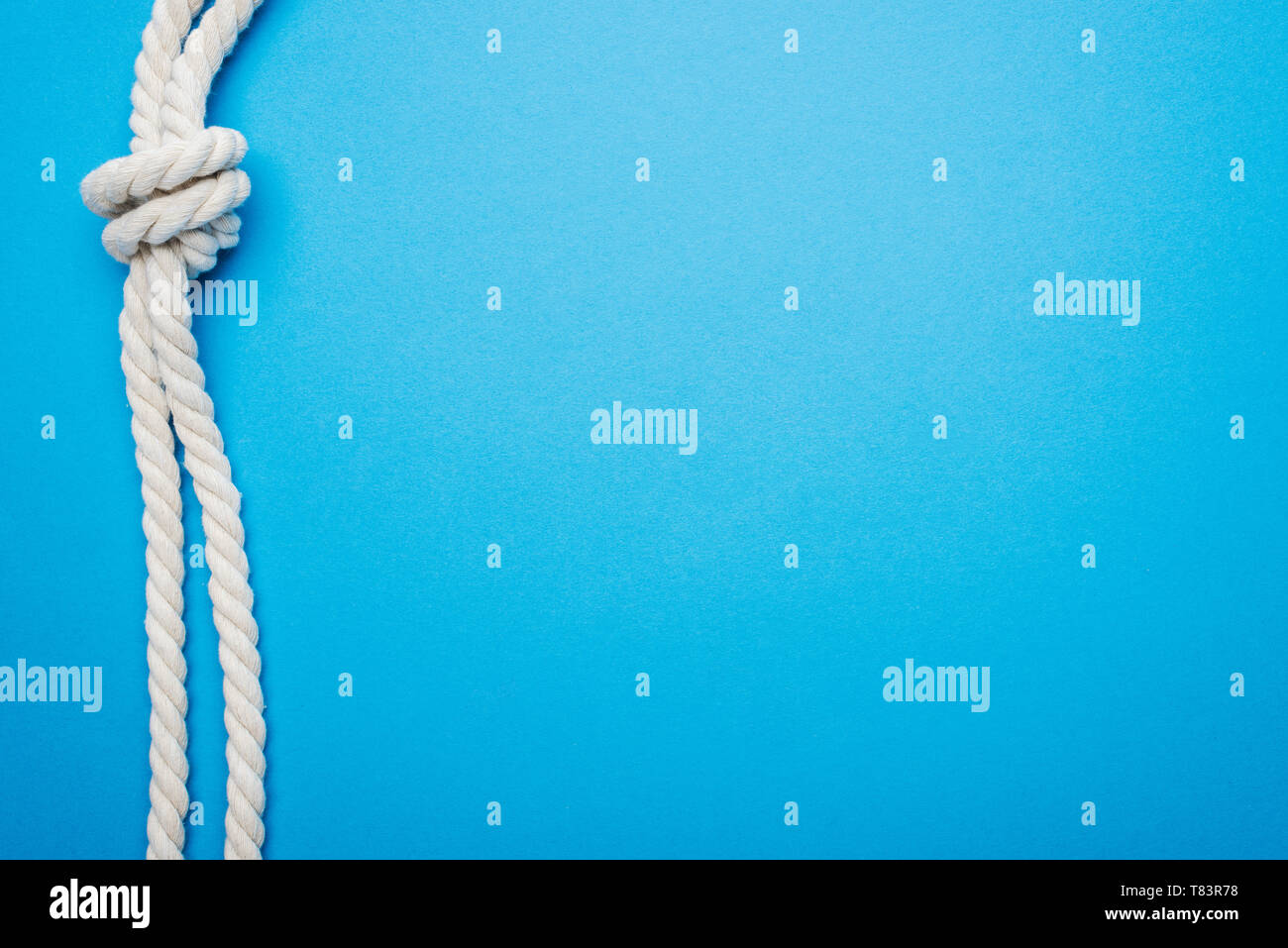 white long ropes with sea knot isolated on blue Stock Photo - Alamy