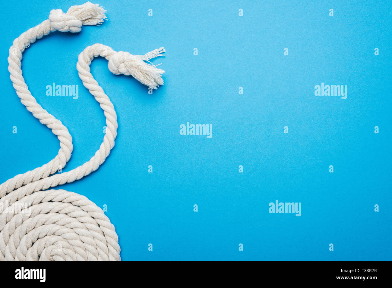 white waved and twisted ropes with knots isolated on blue Stock Photo ...