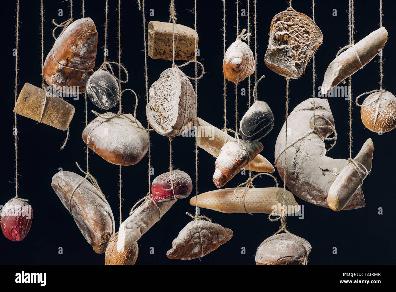 bread with flour hanging on strings isolated on black Stock Photo - Alamy