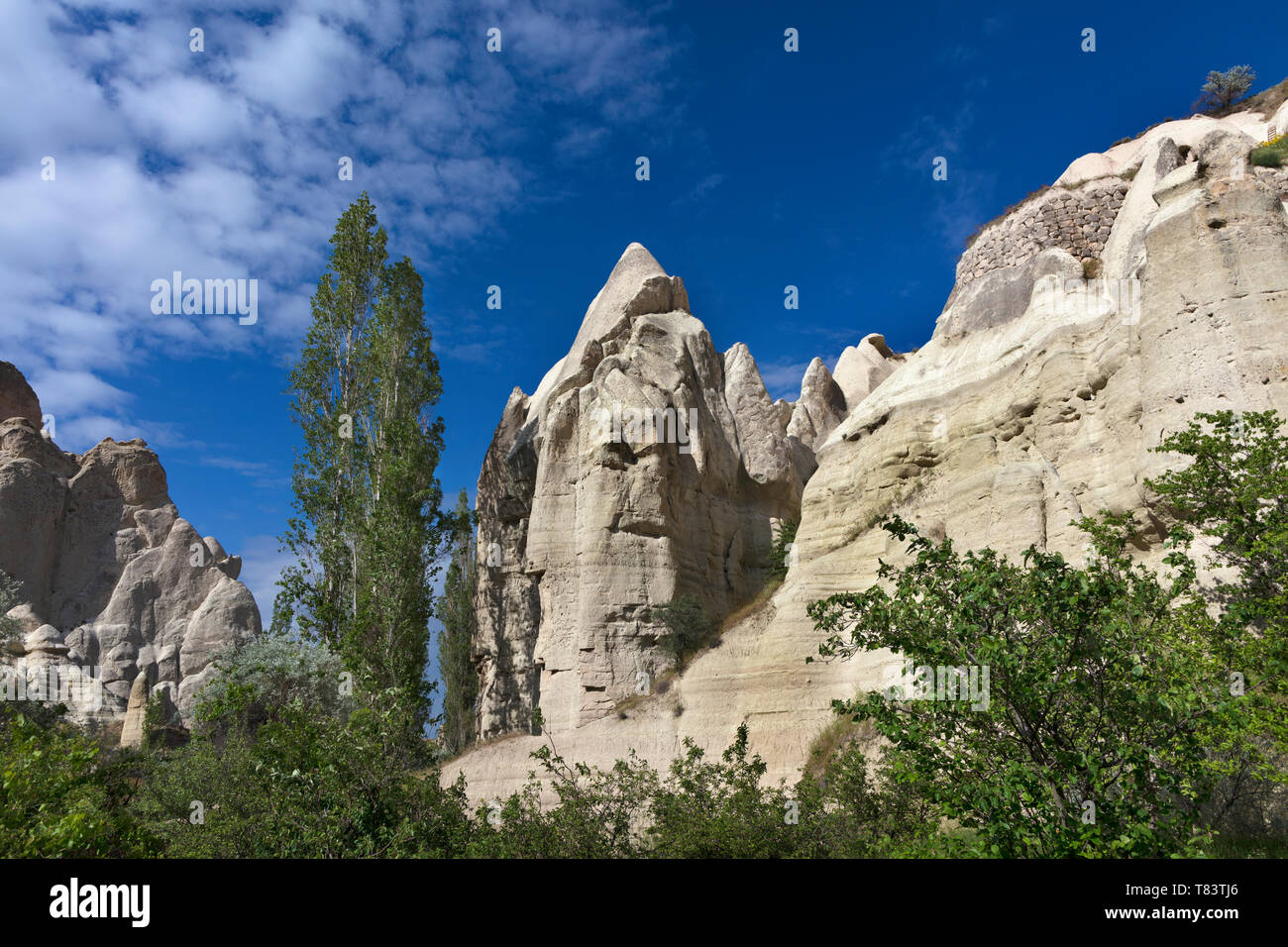 Red and white sandstone cliffs, ancient caves in a mountain landscape ...