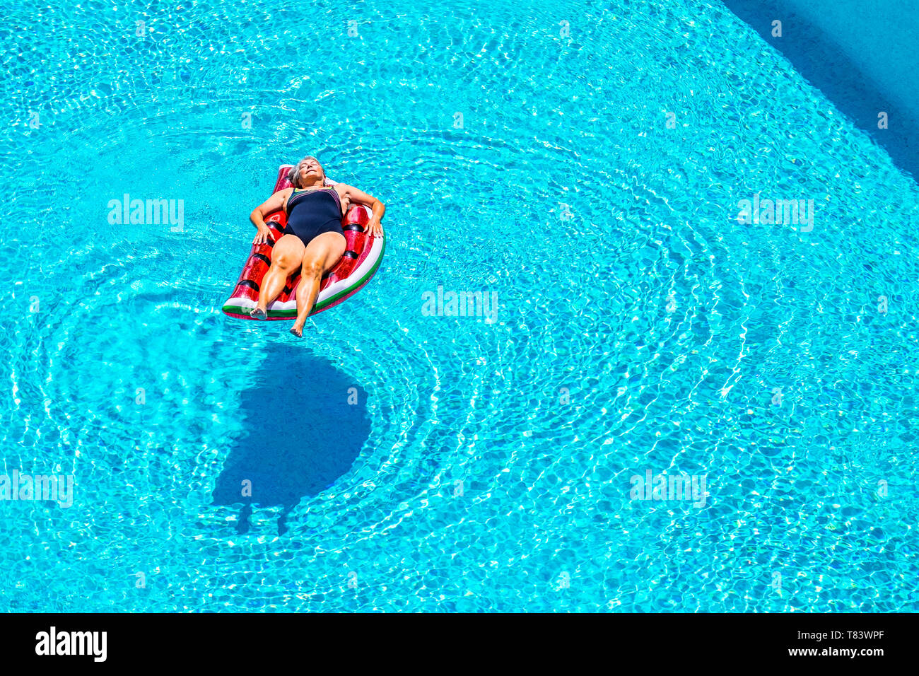 Senior aged lady sleep and relax enjoying the blue water of swimming ...