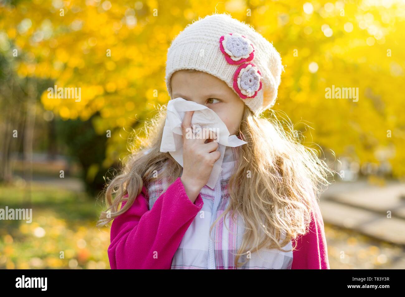 Girl child with cold rhinitis on autumn background. Fall flu season ...