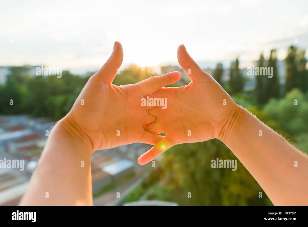 Gesture two hands together, background evening sunset, city silhouette ...