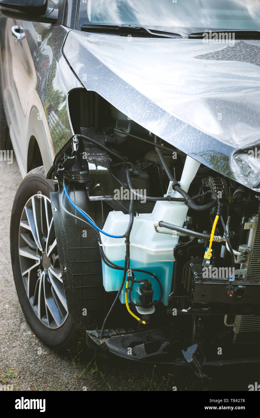 Broken and crashed modern grey car after an accident on street, damaged ...