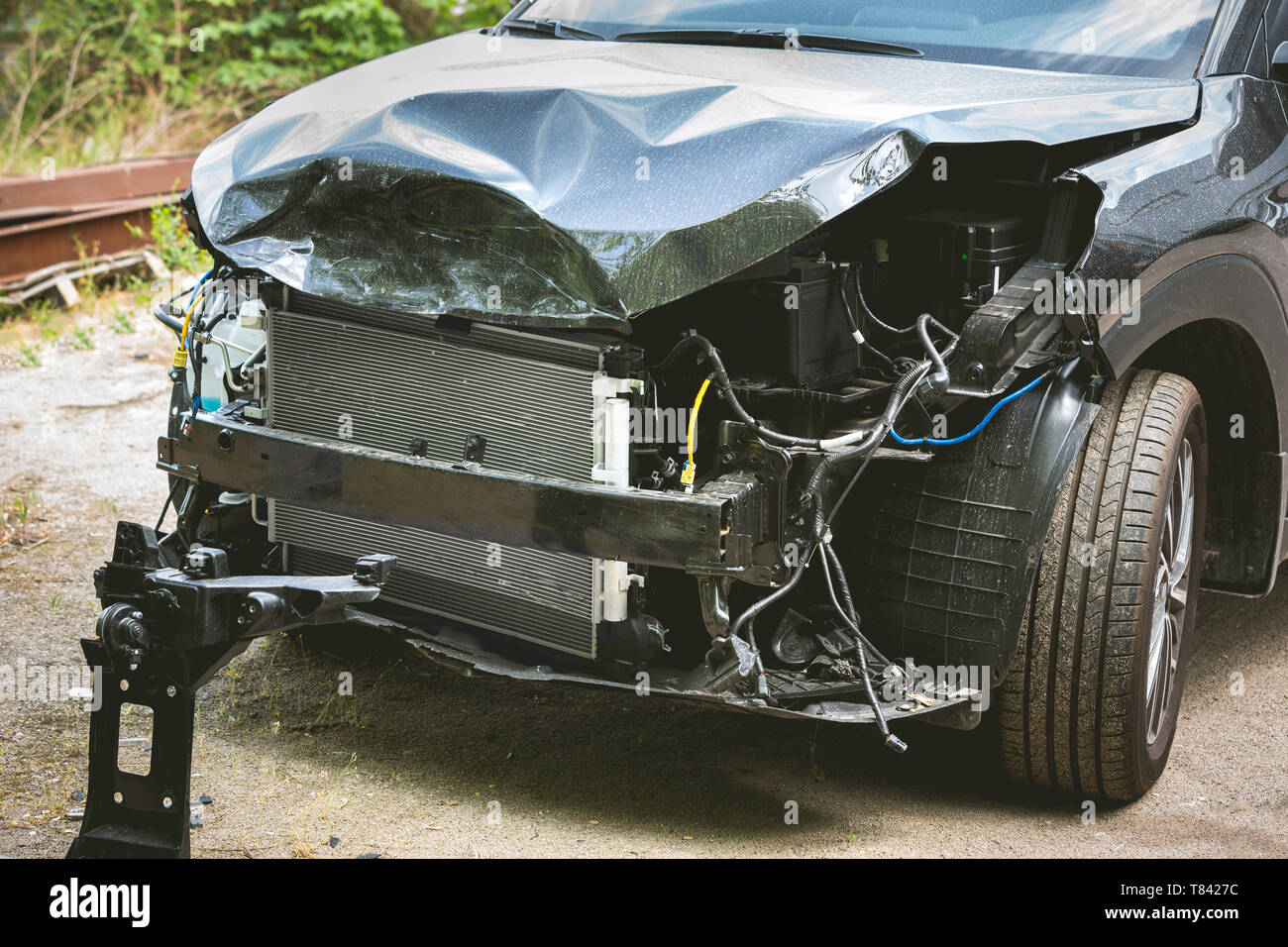 Broken and crashed modern black car after an accident on street ...