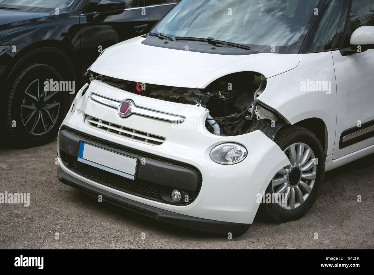 Broken and crashed modern white car after an accident on street ...