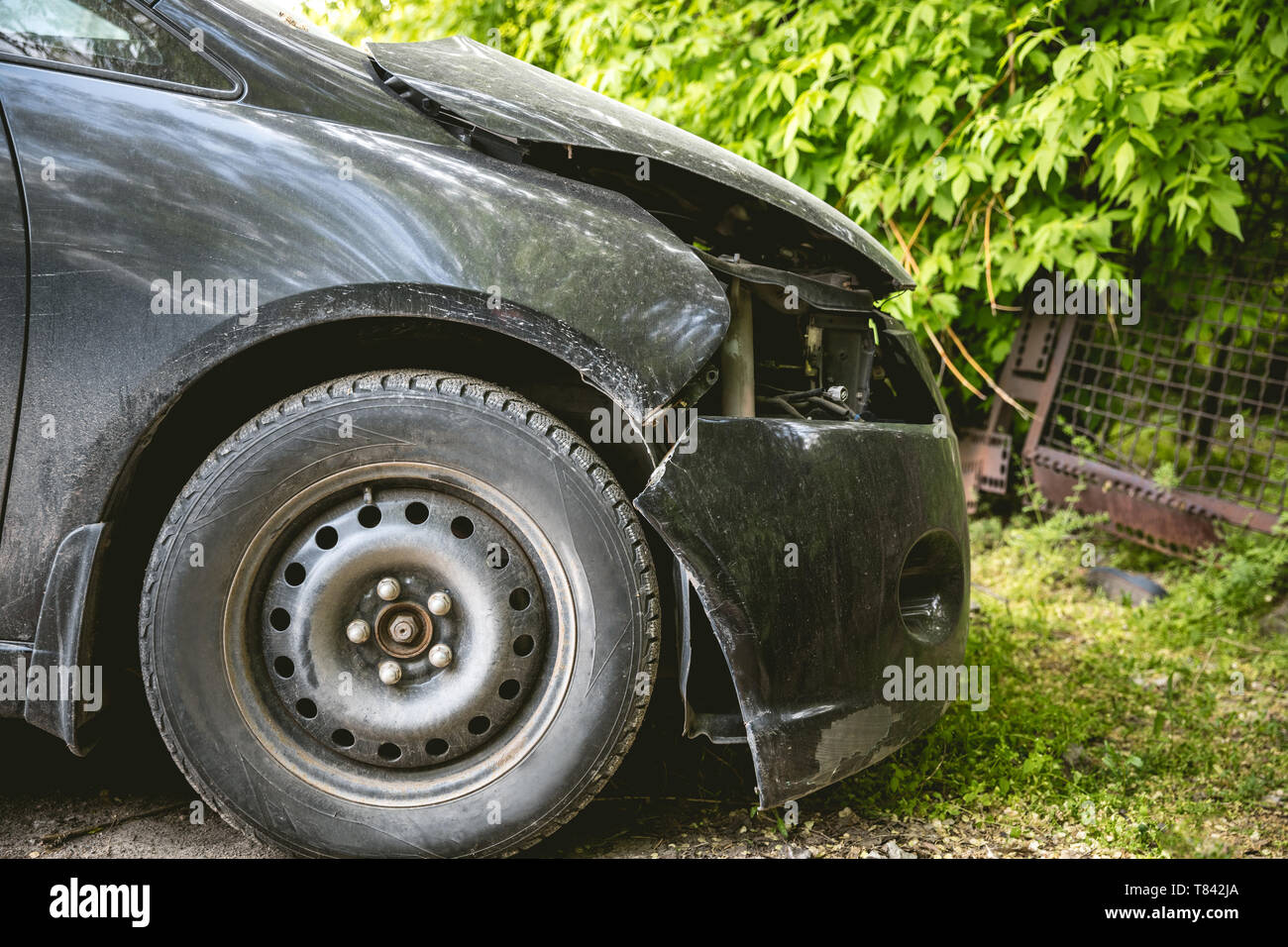 Broken and crashed modern black car after an accident on street ...