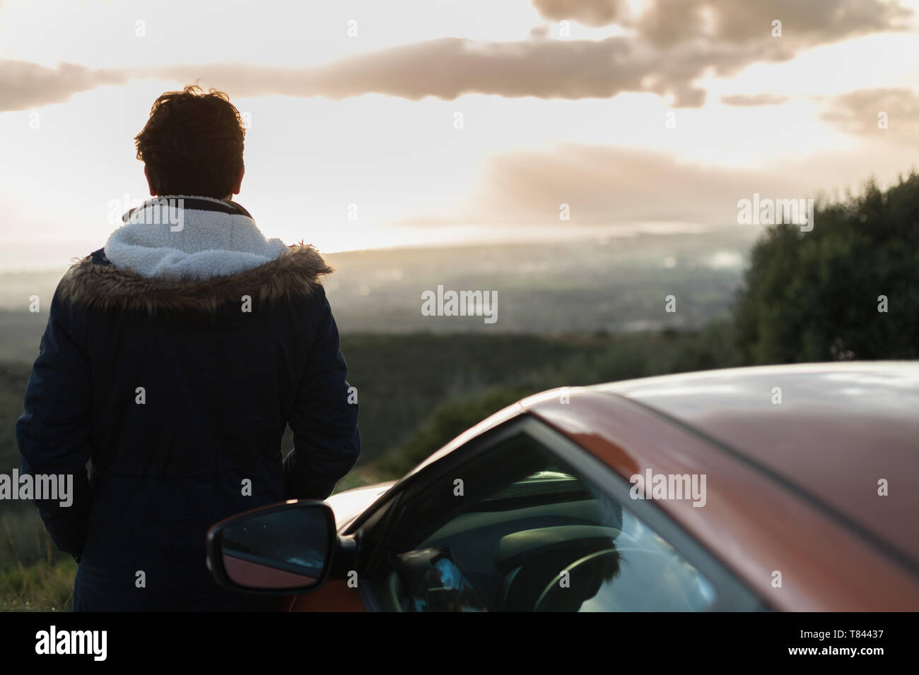 Man resting against car on roadside, enjoying view on hilltop Stock ...