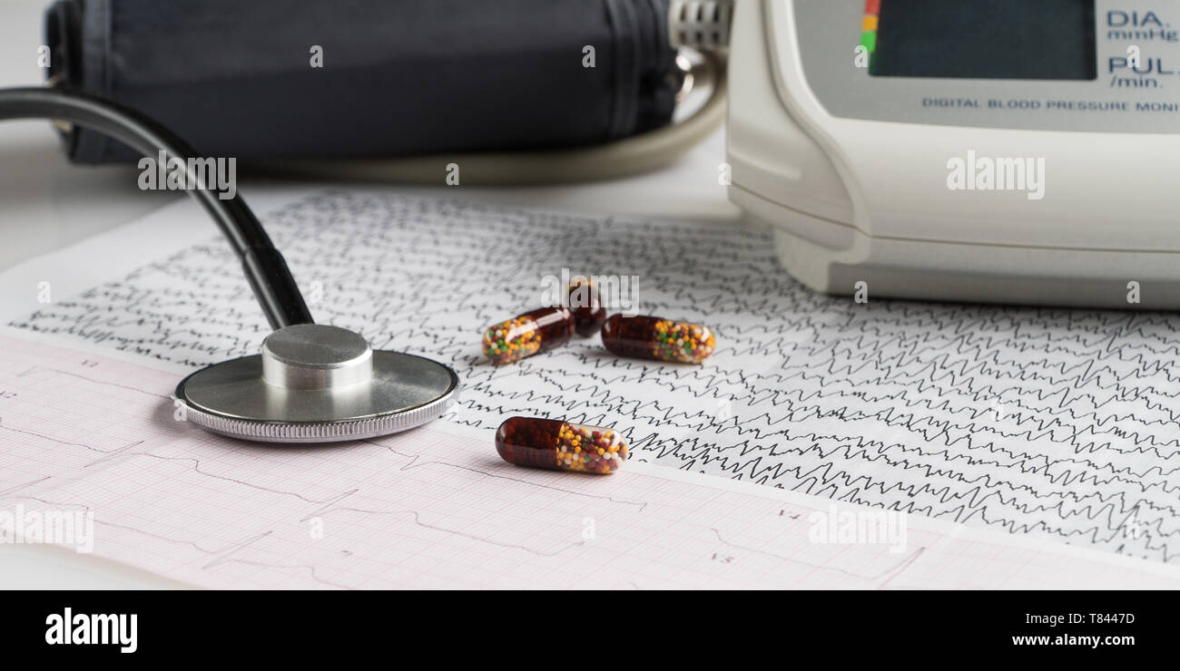 modern electric tonometer and a stethoscope on a cardiogram chart ...