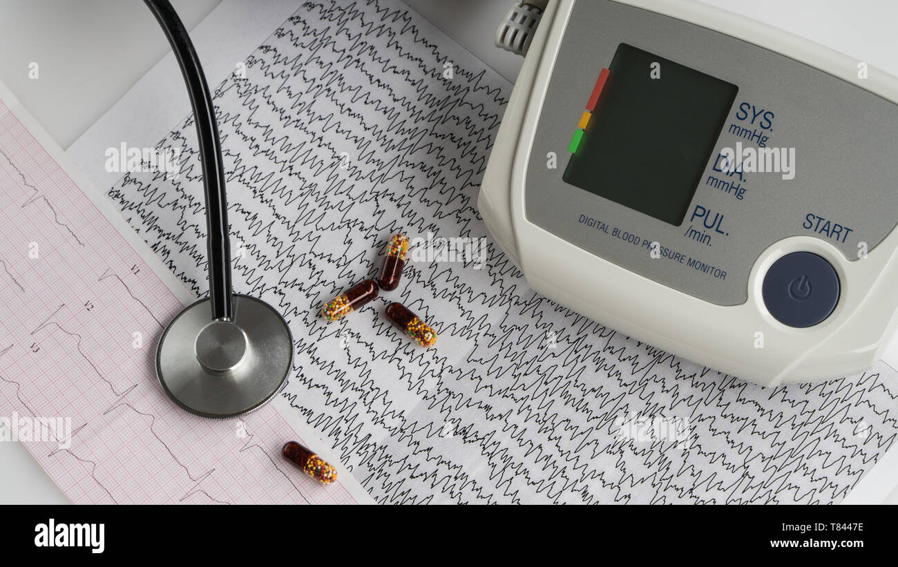 modern electric tonometer and a stethoscope on a cardiogram chart ...