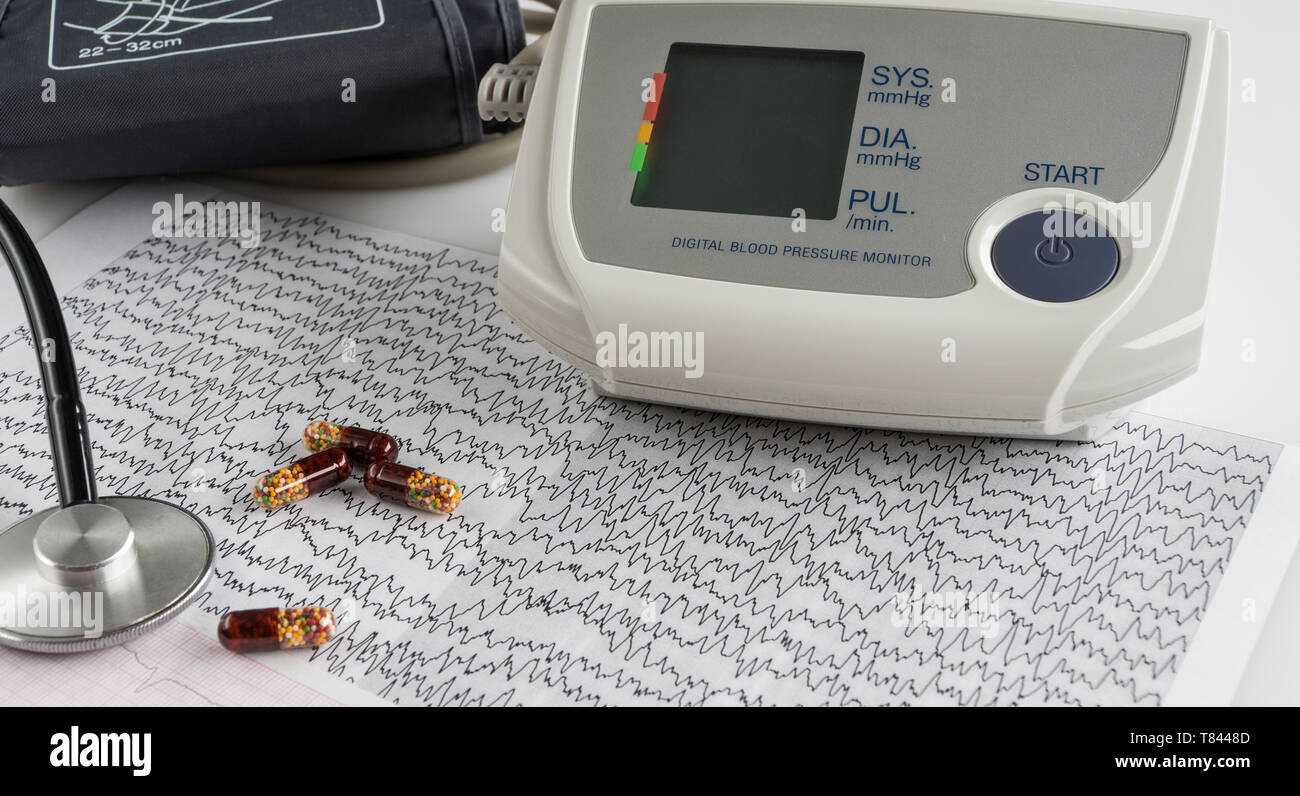 modern electric tonometer and a stethoscope on a cardiogram chart ...