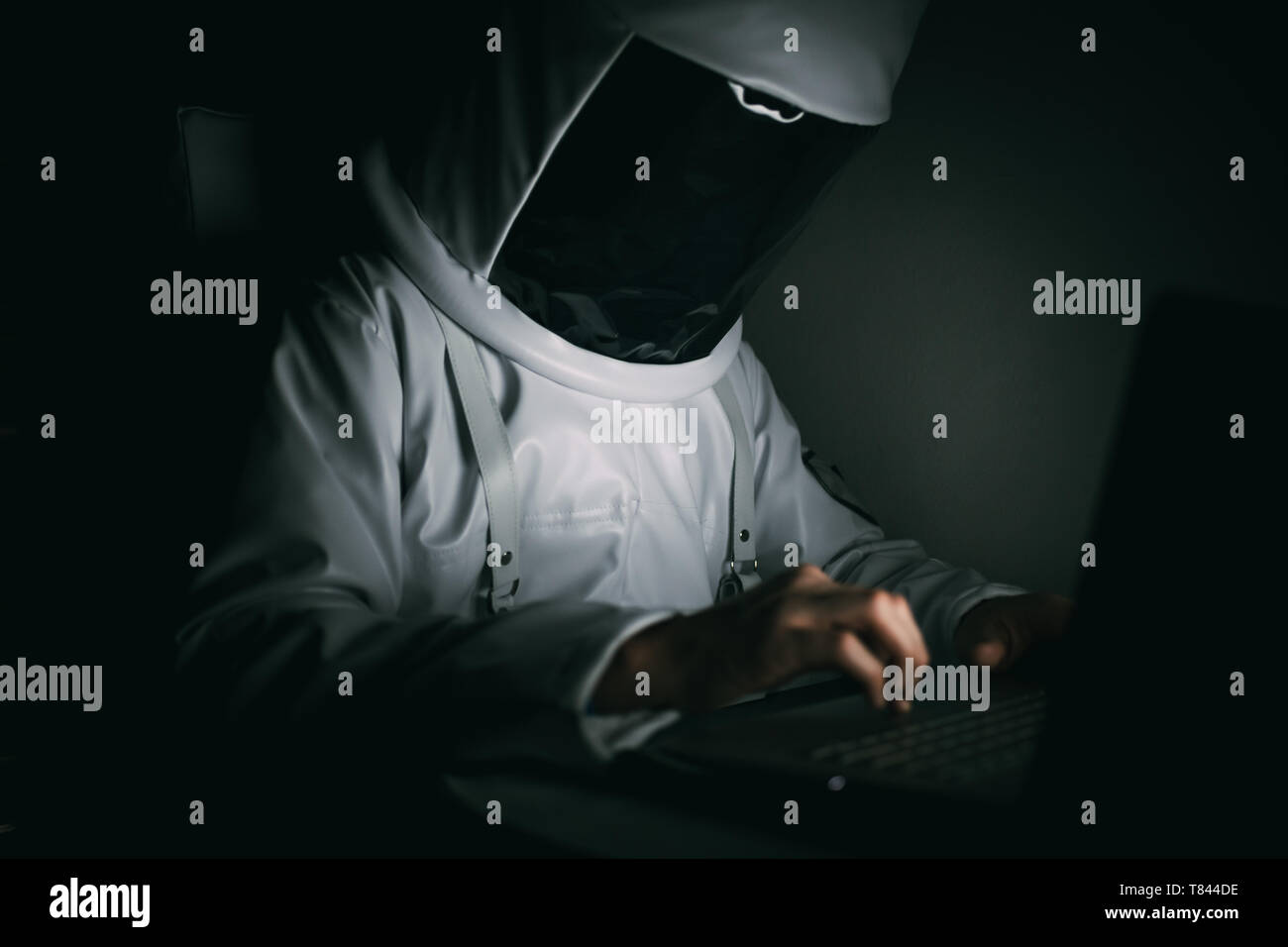 Astronaut using laptop in dark room Stock Photo - Alamy