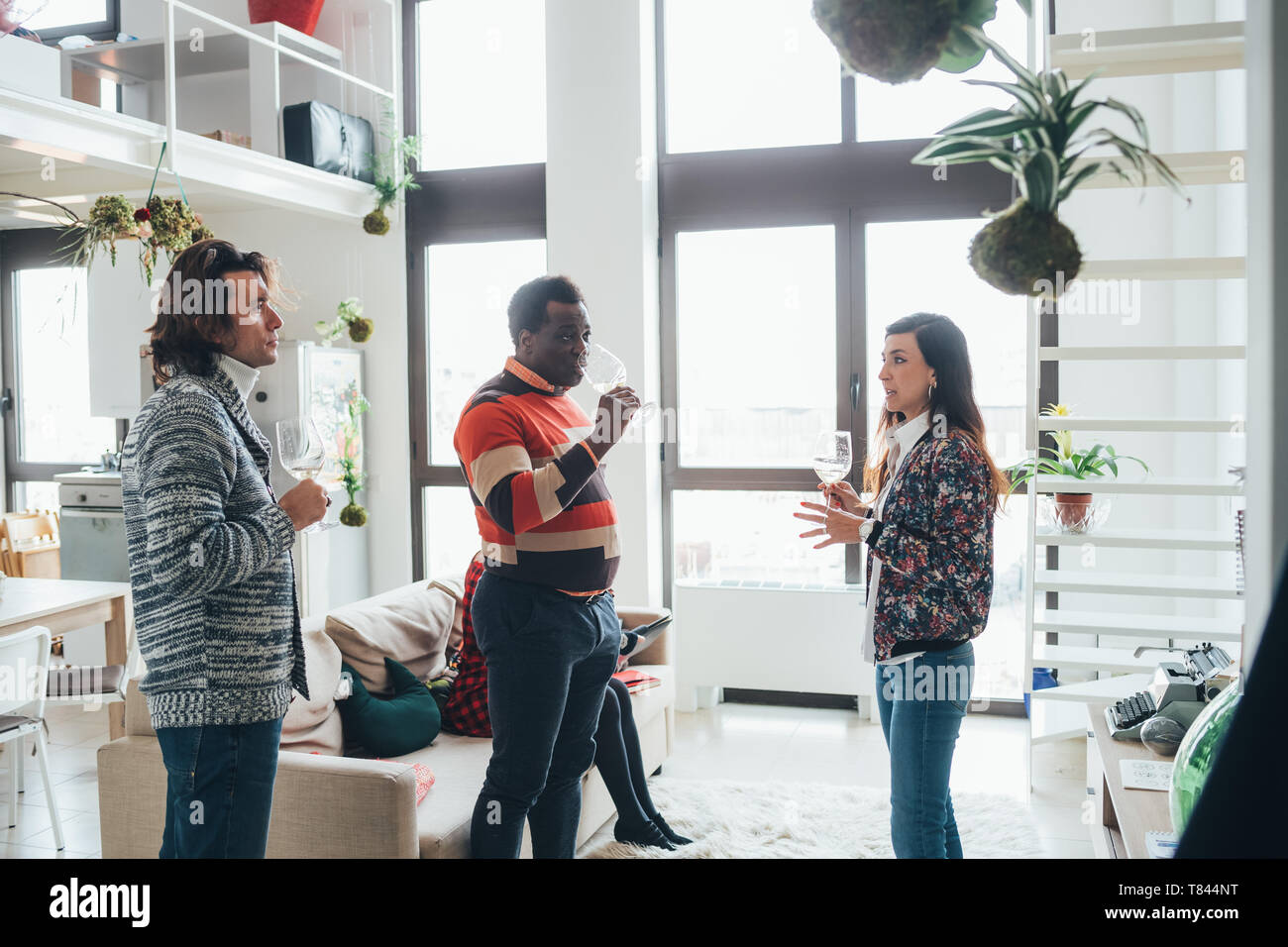 Friends talking at party in loft office Stock Photo - Alamy