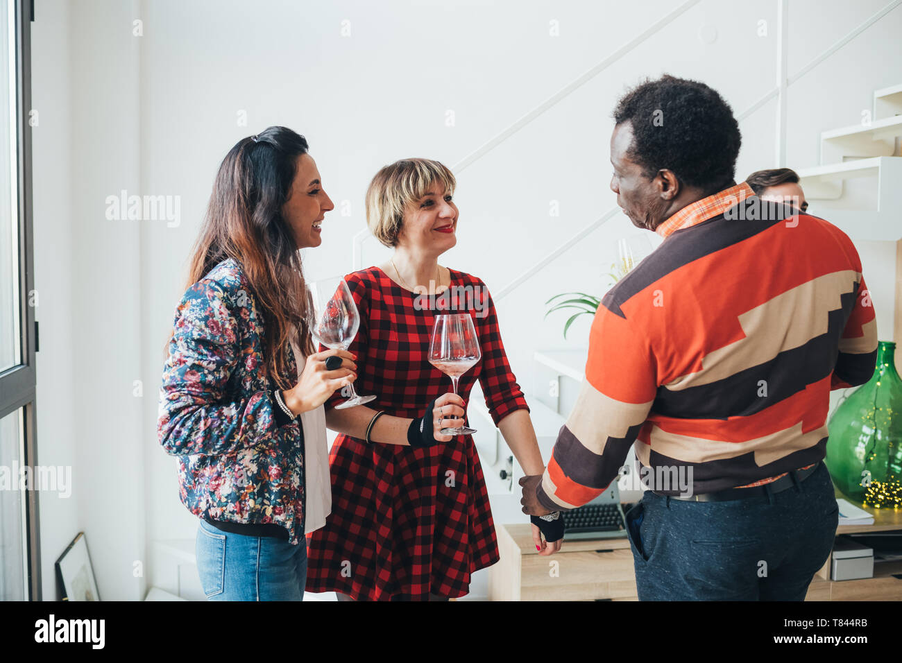 Friends talking at party in loft office Stock Photo - Alamy
