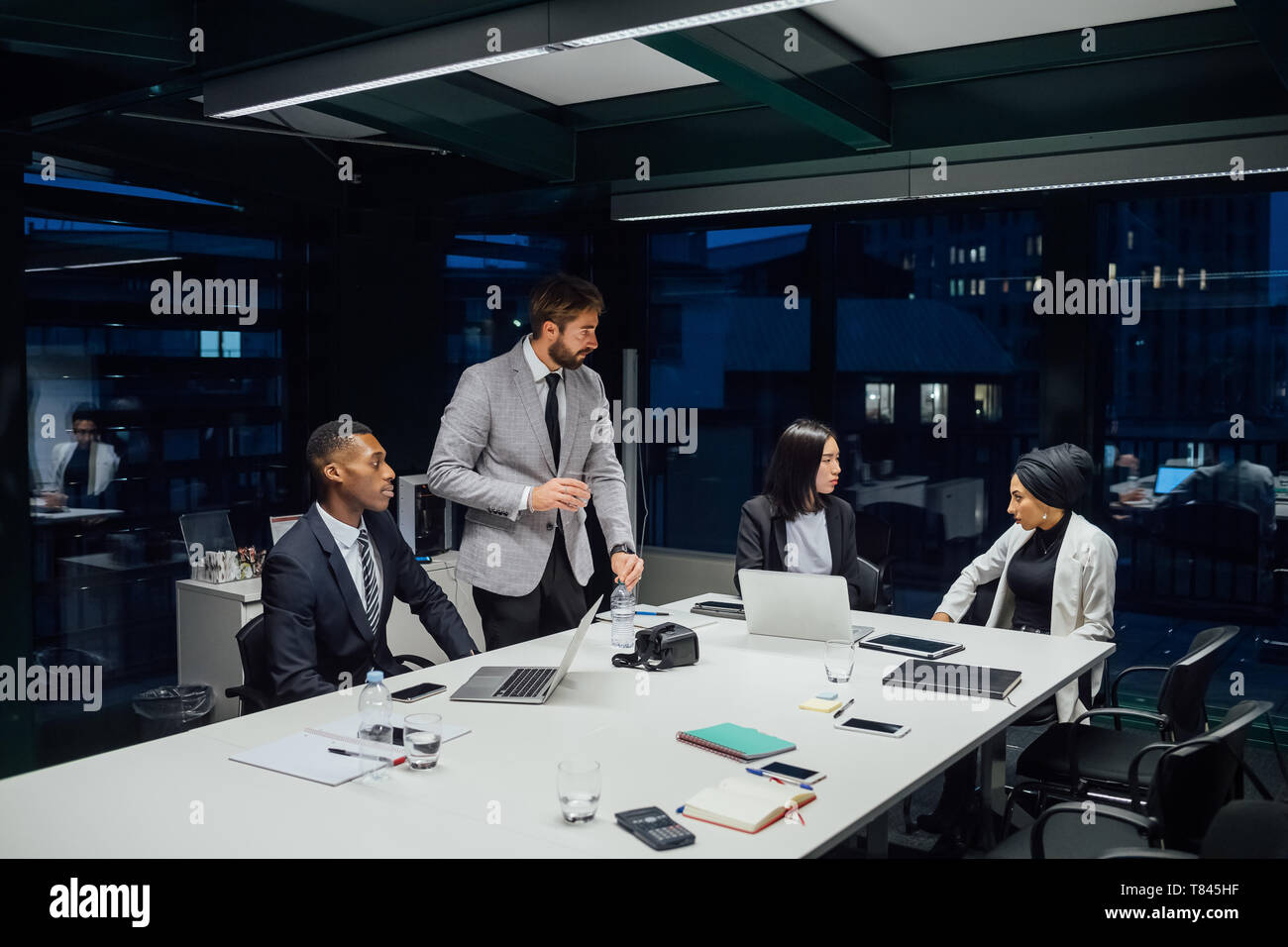 Businesswomen and men having discussion during conference table meeting ...