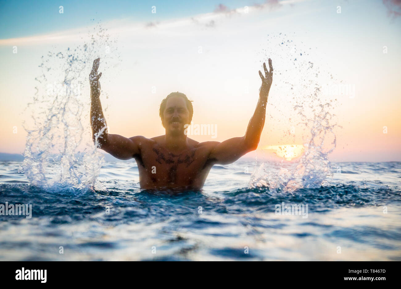 Man splashing in sea at sunset, Pagudpud, Ilocos Norte, Philippines ...