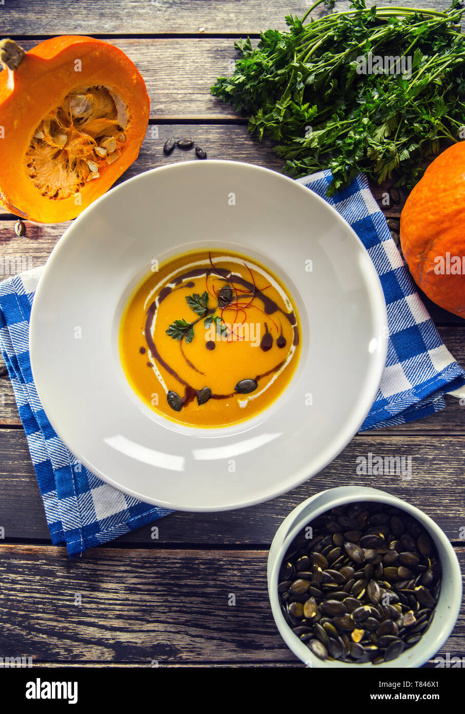 Pumpkin cream soup with seeds and parsley on kitchen table - Top of ...