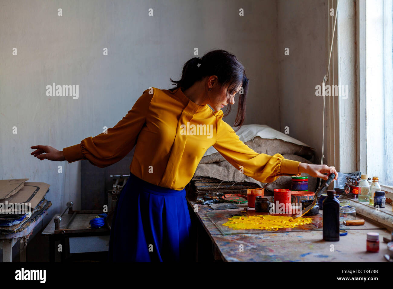 Woman creating art with scraper Stock Photo - Alamy